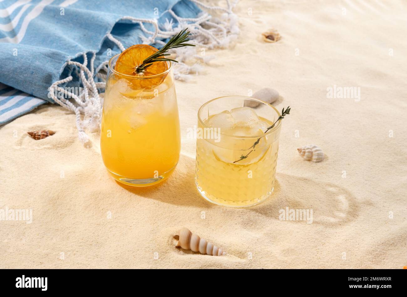 Selection of summer alcoholic cocktails on a wicker tray on beach with ...