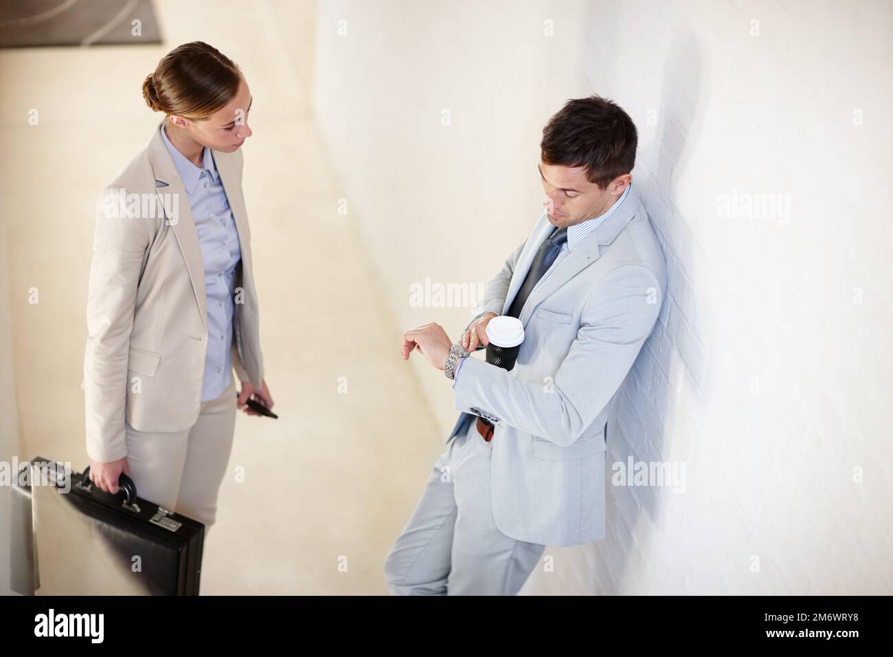 Early bird catches the worm. Two businesspeople standing in the office ...