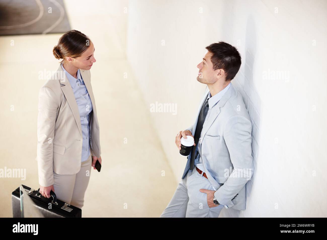 Suited up. Two businesspeople standing in the office having a ...
