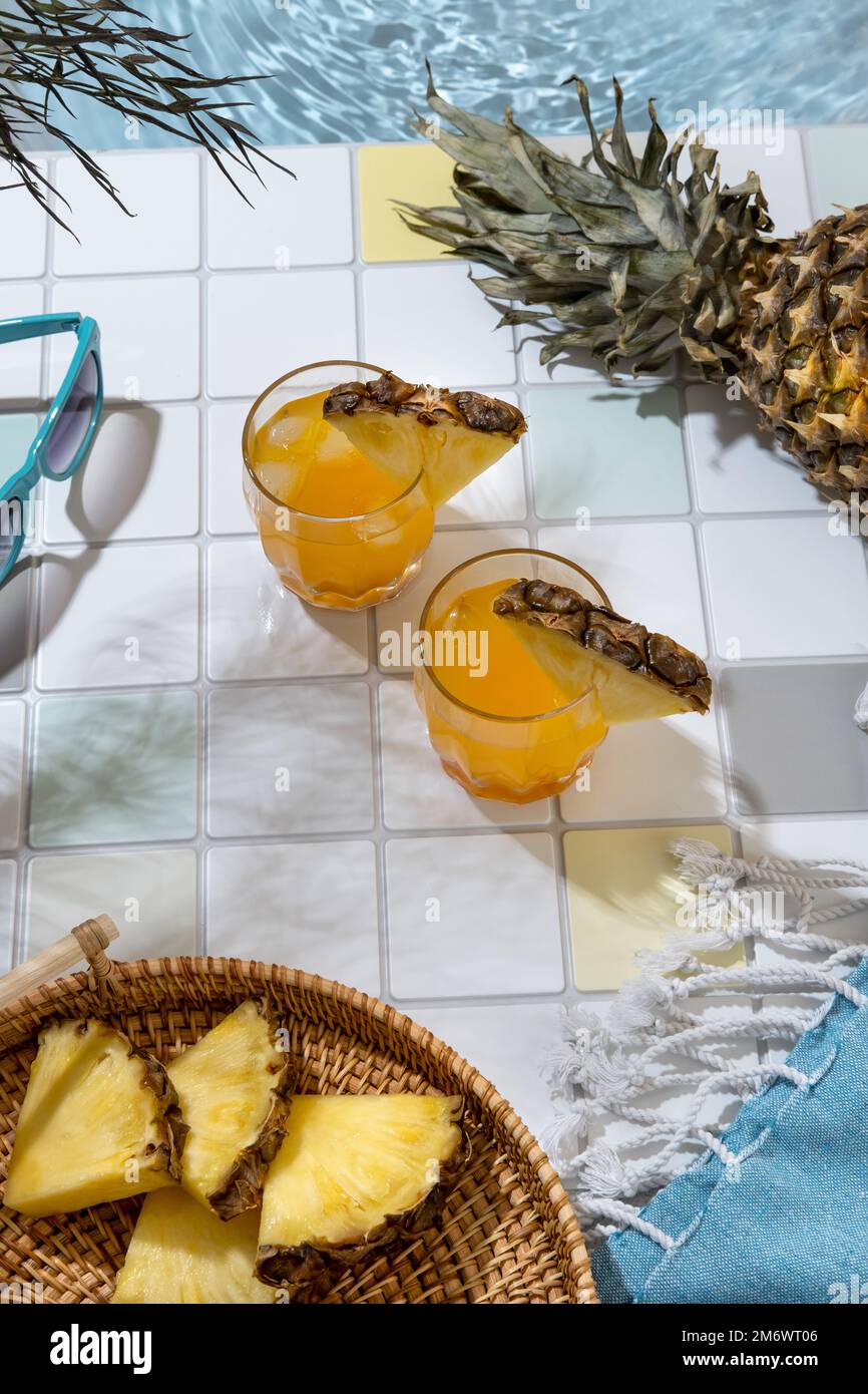 Two pineapple cocktail on edge of swimming pool. Summer vacation and ...