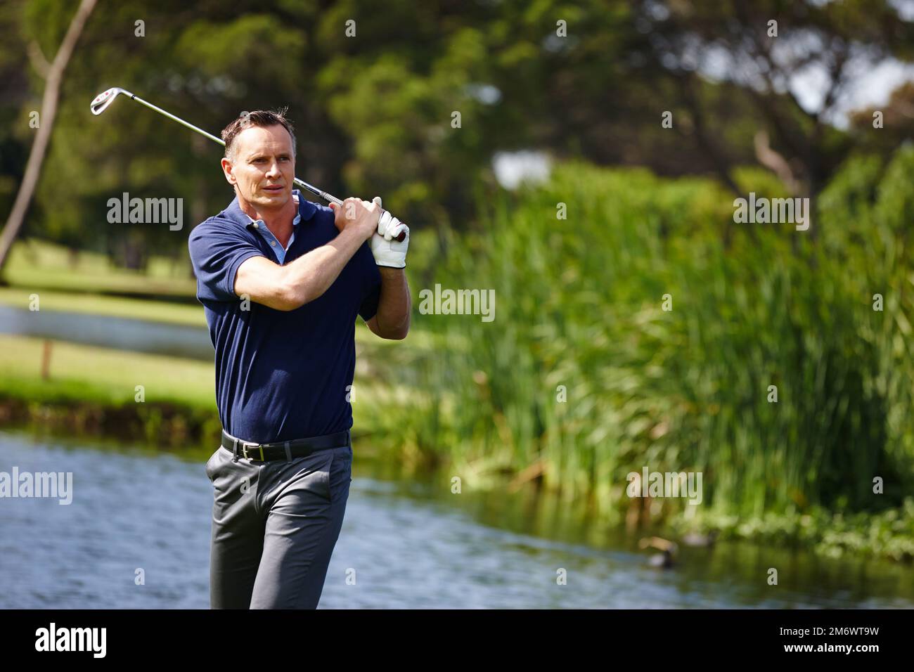 Take another swing at it. a man taking a swing in a game of golf Stock ...