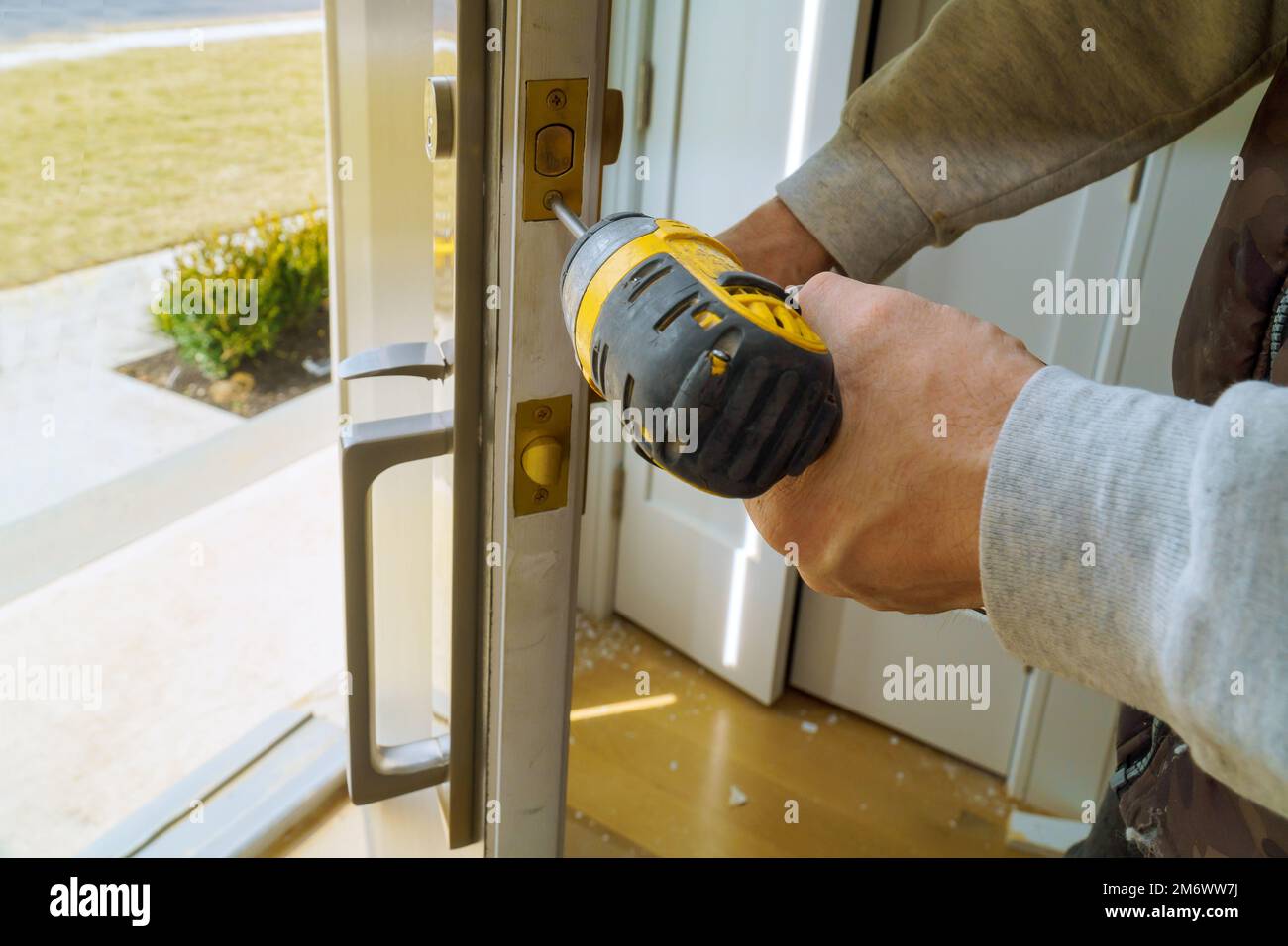 Worker installing lock in new house with using screwdriver Stock Photo ...