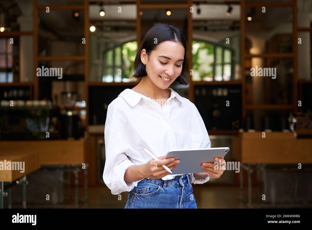 Young asian waitress, cafe manager working with tablet and graphic ...