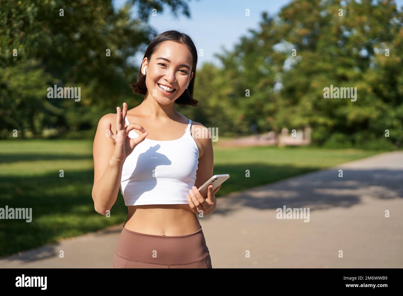 Sport people. Happy asian girl, sportswoman showing okay sign and ...