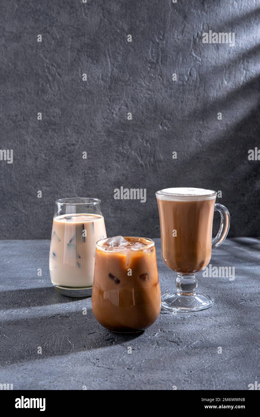 Ice coffee in a tall glass with cream poured over and coffee beans ...