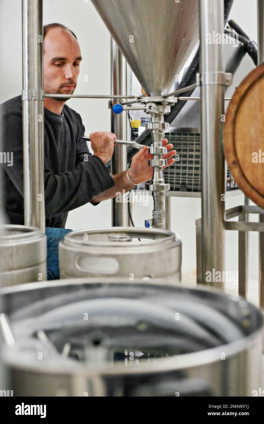 Monitoring brewing from start to finish. a man working in a ...