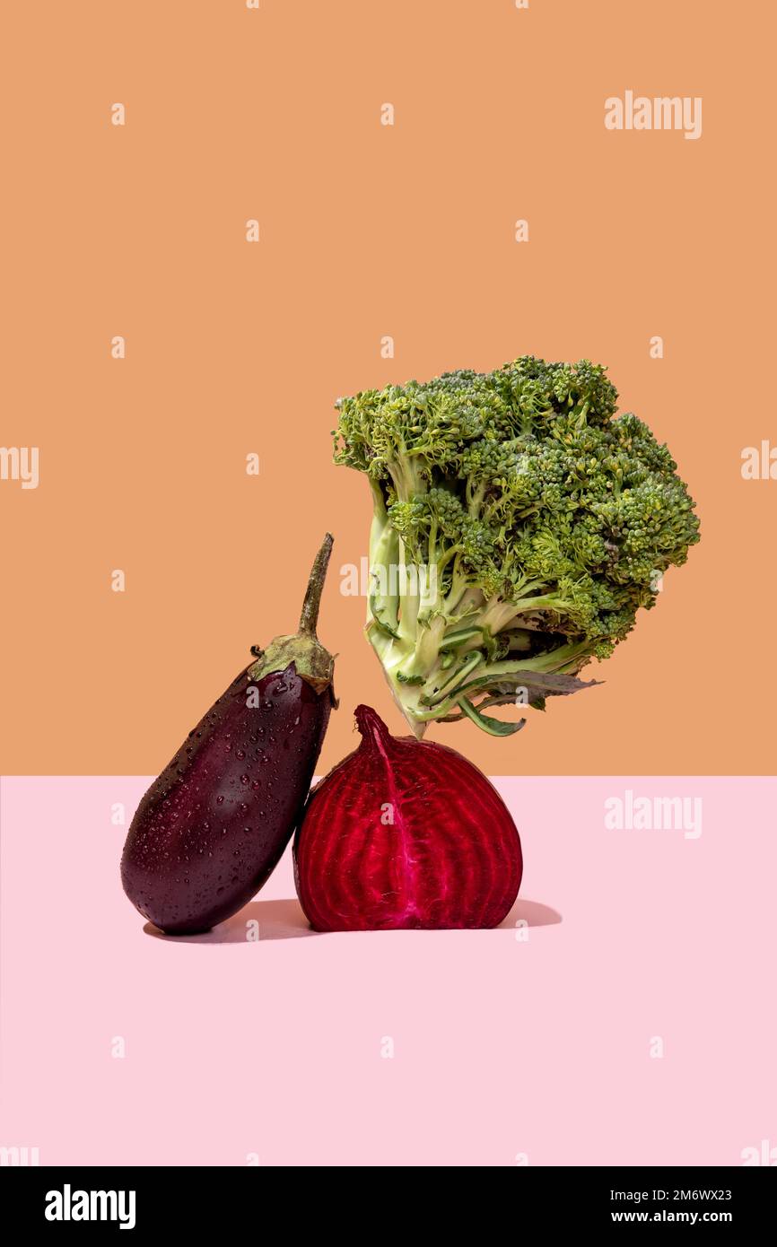 Broccoli, beet and eggplant on a light background. Modern still life ...