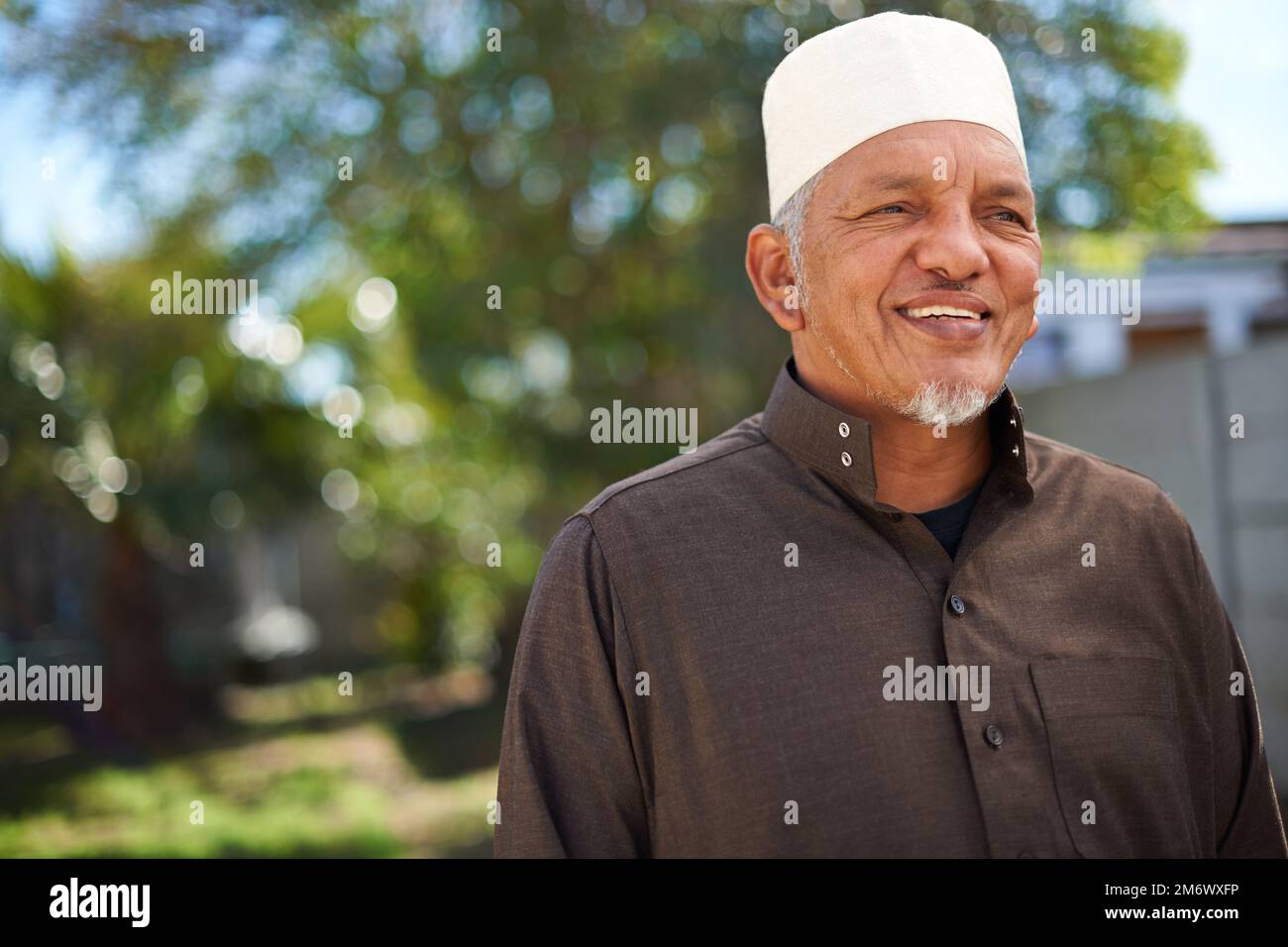 Appreciating this beautiful day. a mature muslim man standing outside ...
