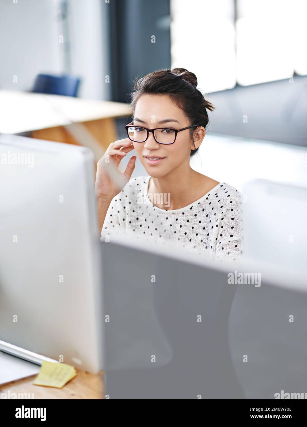 Make creativity a job. a young office worker sitting at her workstation ...