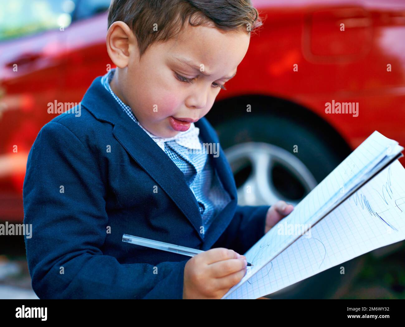 Need to get down some ideas. a young muslim boy in a suit writing on ...