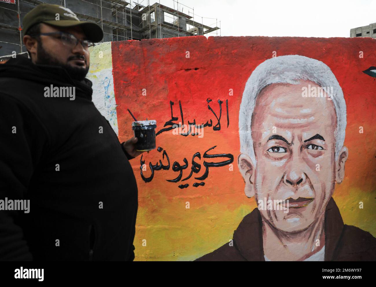 An artist paints a mural dedicated to Palestinian prisoner Karim Younes ...