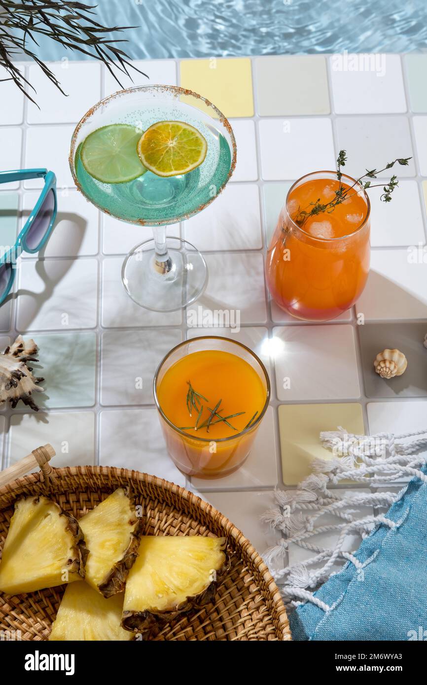 Three Ñ olorful tropical cocktail on edge of swimming pool. Summer ...