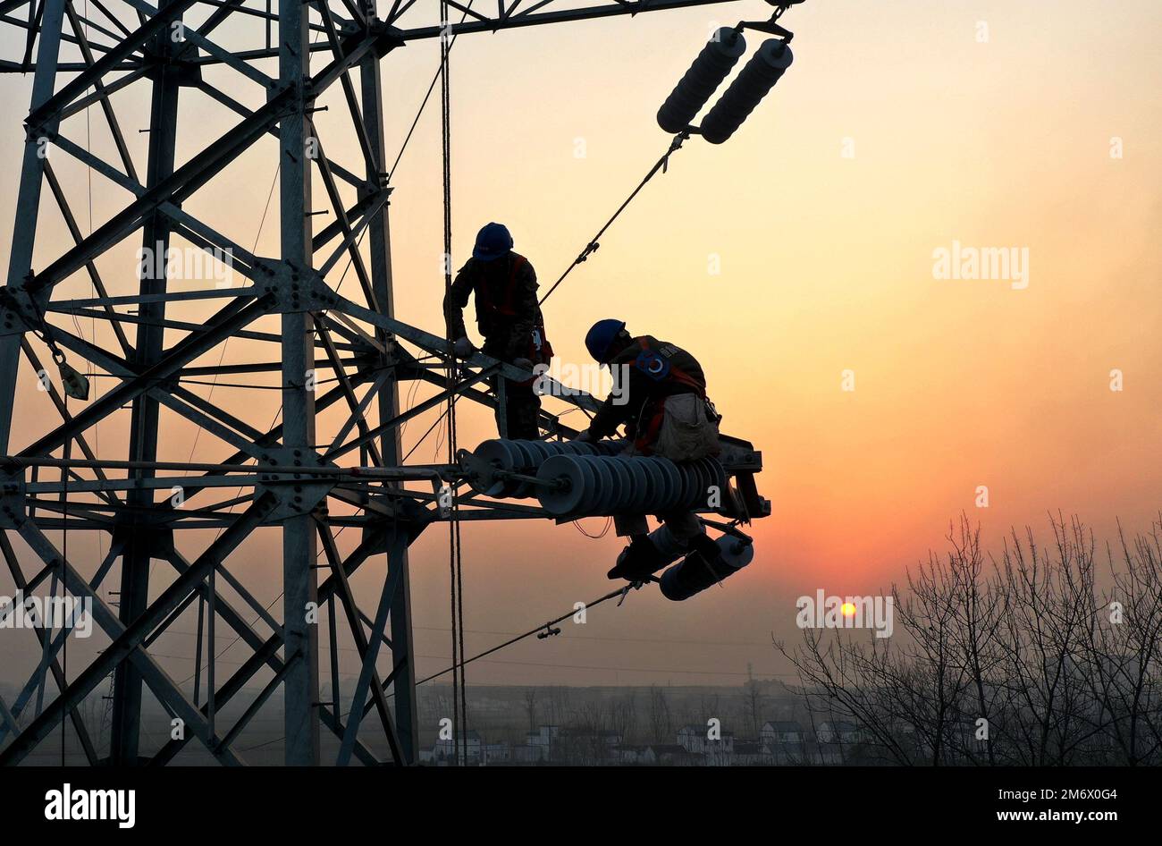 XUZHOU, CHINA - JANUARY 5, 2023 - Workers work on a 110 kv line tower ...