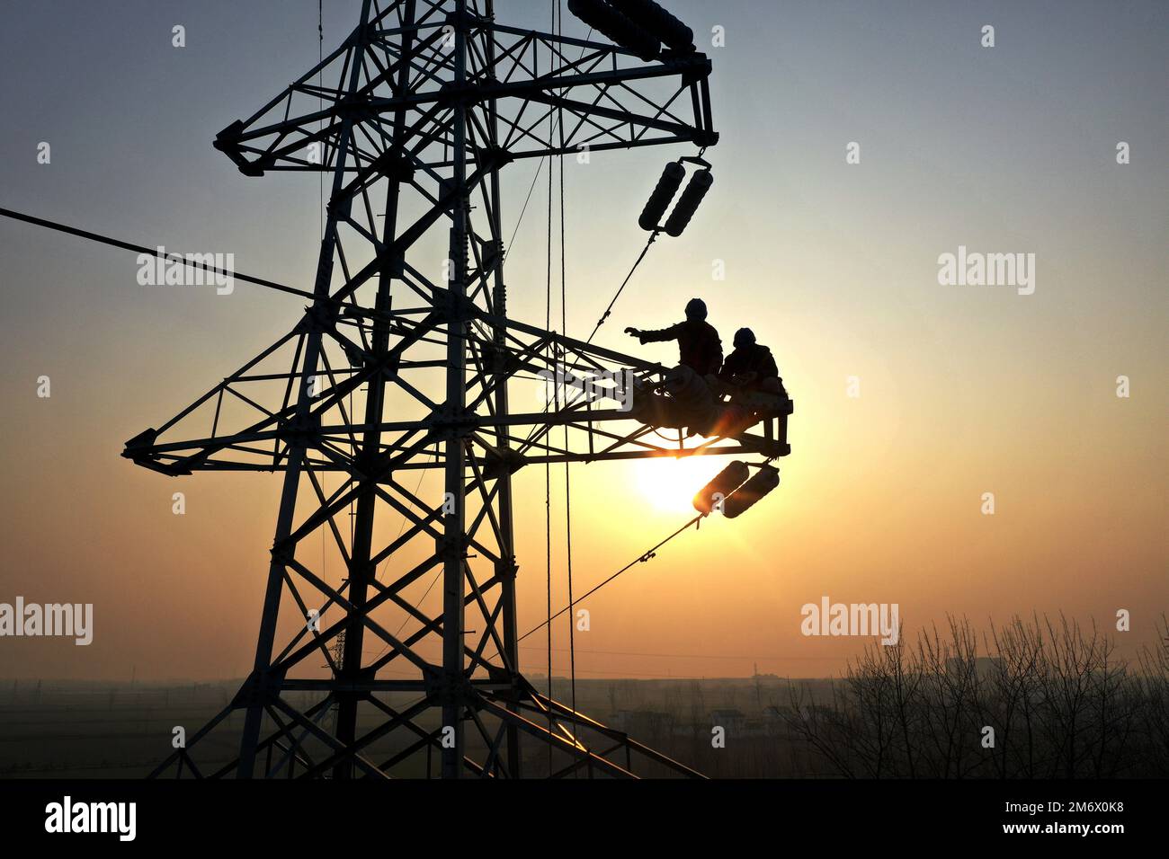 XUZHOU, CHINA - JANUARY 5, 2023 - Workers work on a 110 kv line tower ...