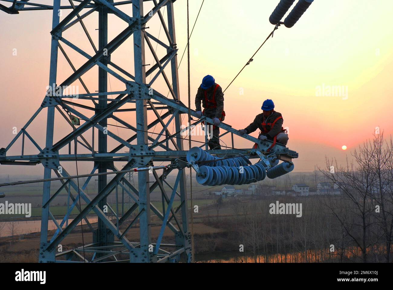 XUZHOU, CHINA - JANUARY 5, 2023 - Workers work on a 110 kv line tower ...
