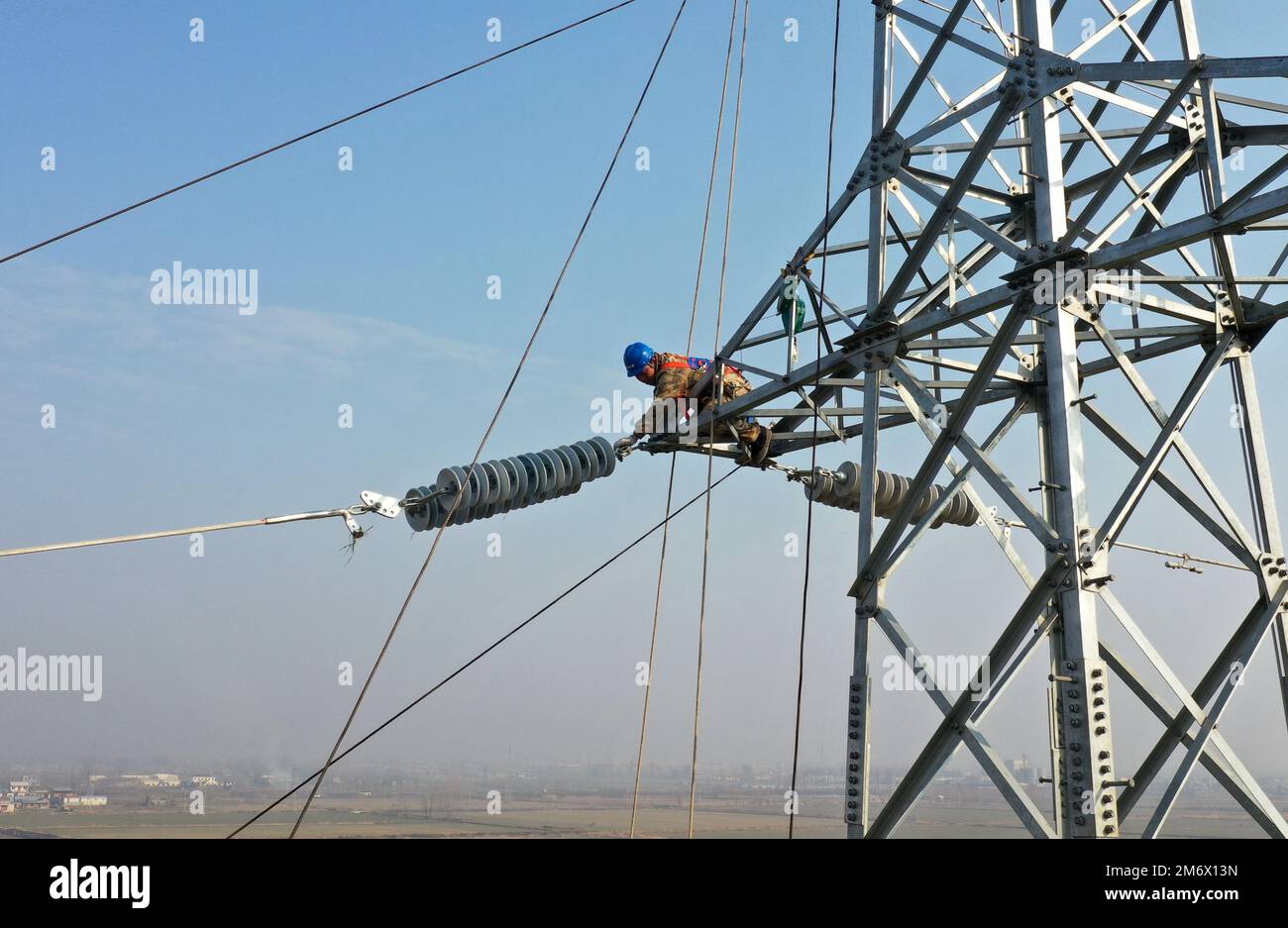 XUZHOU, CHINA - JANUARY 5, 2023 - Workers work on a 110 kv line tower ...