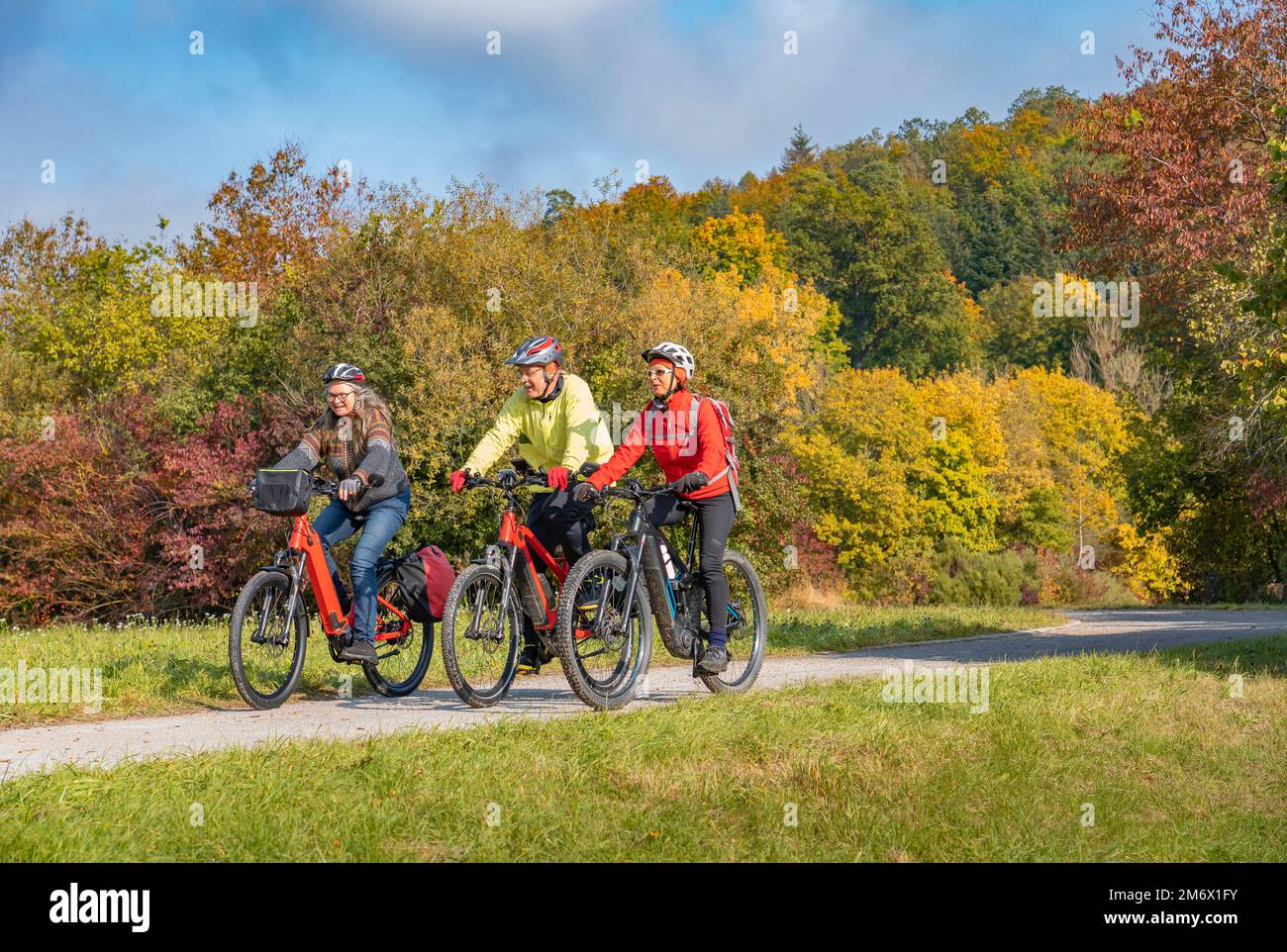 Happy seniors cycling in fall with electric bikes Stock Photo - Alamy