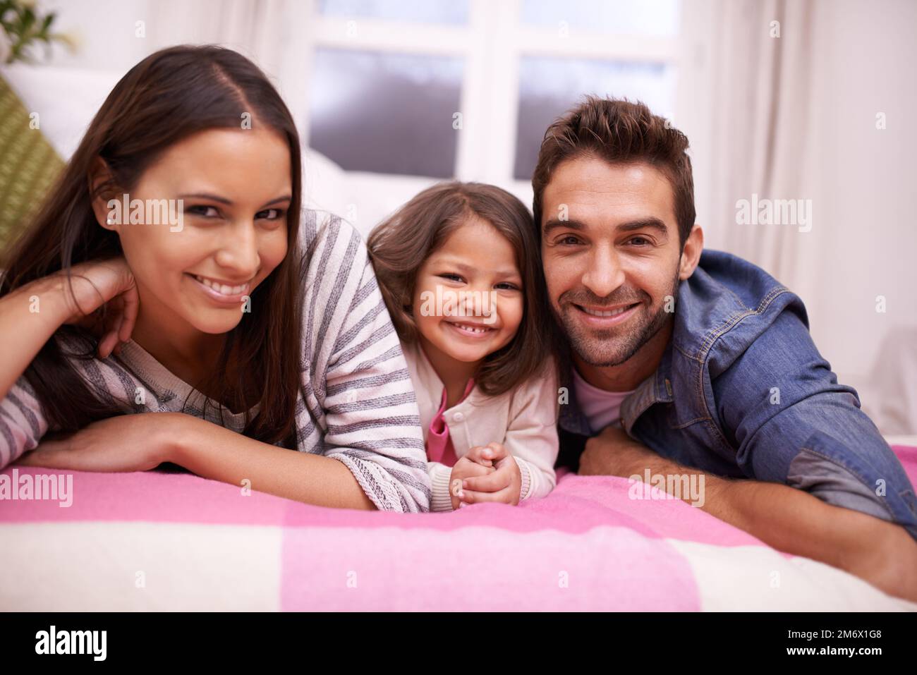 Just hanging together as a family. Portrait of a happy young family at ...