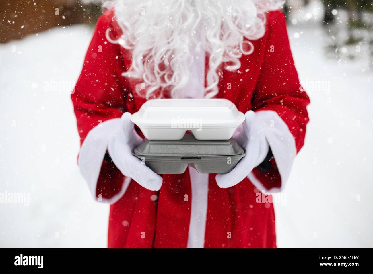 Food delivery service containers in hands of Santa Claus outdoor in ...