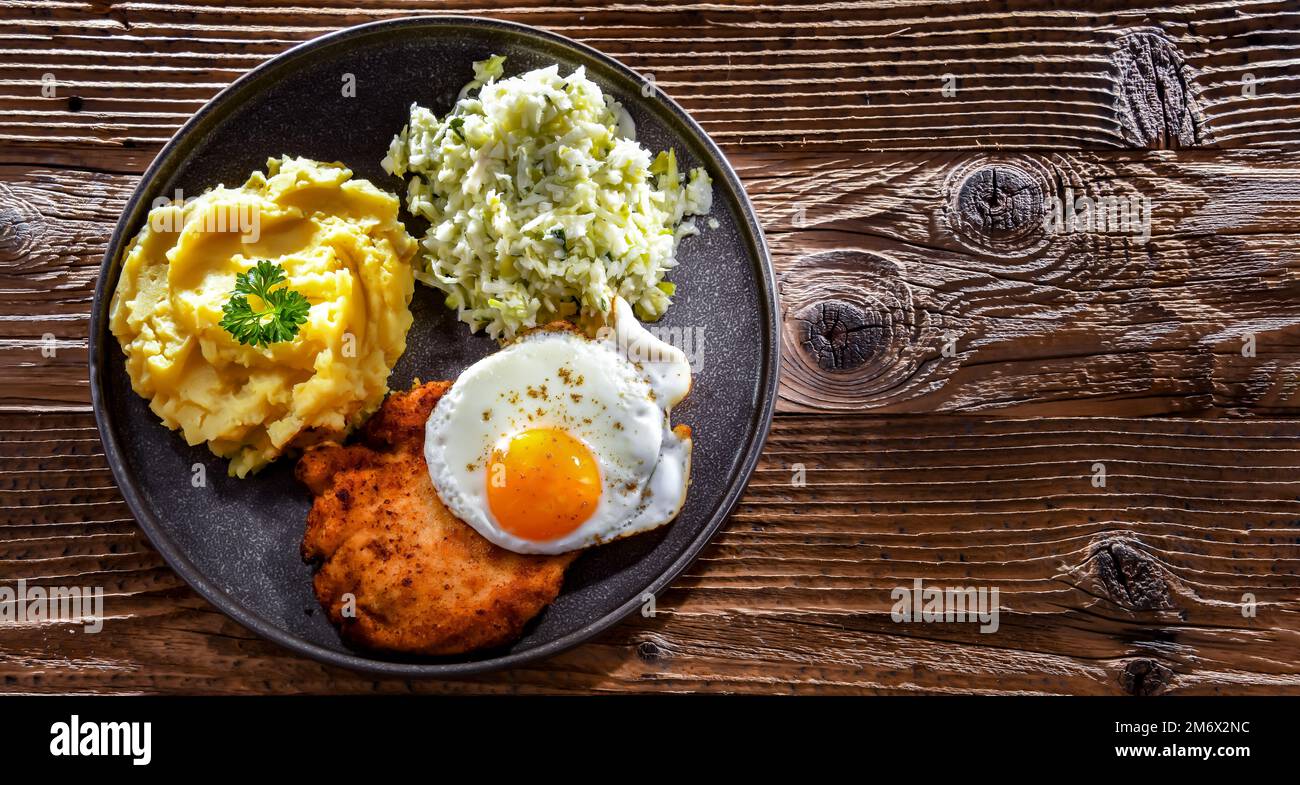 Breaded chicken cutlet served with fried chicken egg Stock Photo - Alamy Breaded chicken cutlet served with fried chicken egg Stock Photo - Alamy