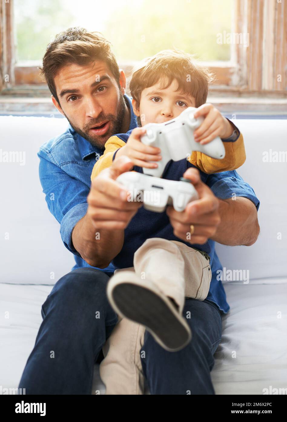 Getting into gaming. a father and his young son playing video games ...
