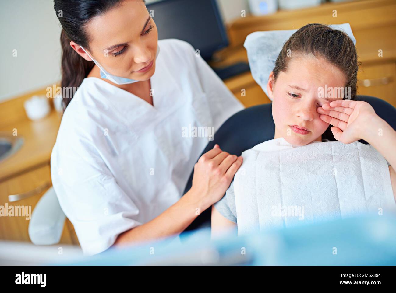 Its only one cavity. a crying little girl sitting in a dentists chair ...