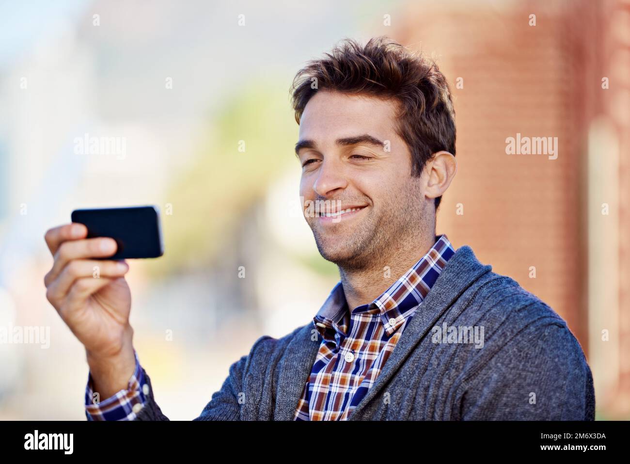 This ones a keeper. a handsome young man taking a photograph with his ...