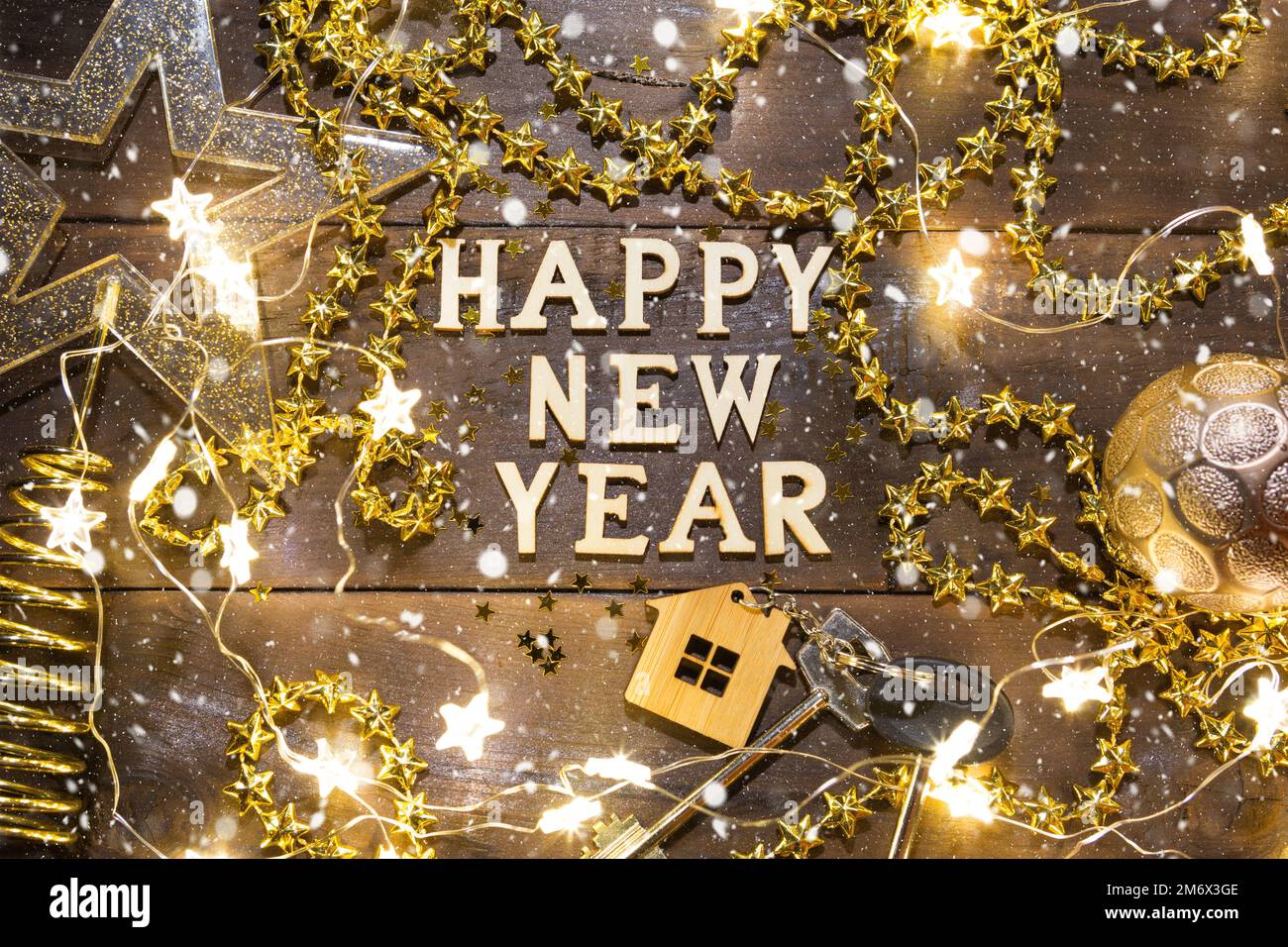 House key with keychain cottage on a festive background with sequins ...