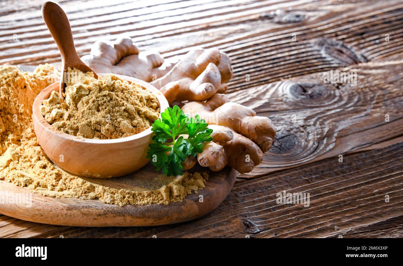 A bowl with ground ginger and its fresh rhizome Stock Photo - Alamy