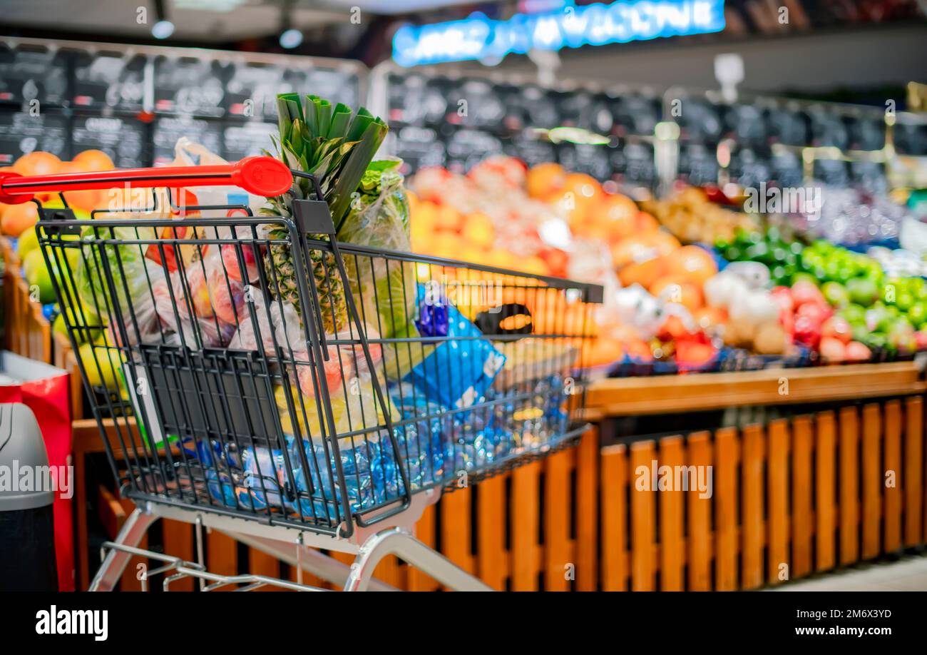 A shopping cart with grocery products in a supermarket Stock Photo - Alamy