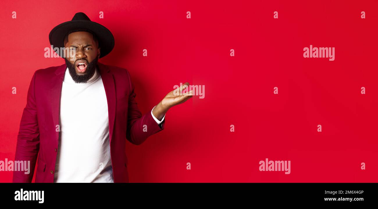 Angry and confused Black man arguing, shouting at camera and raising ...