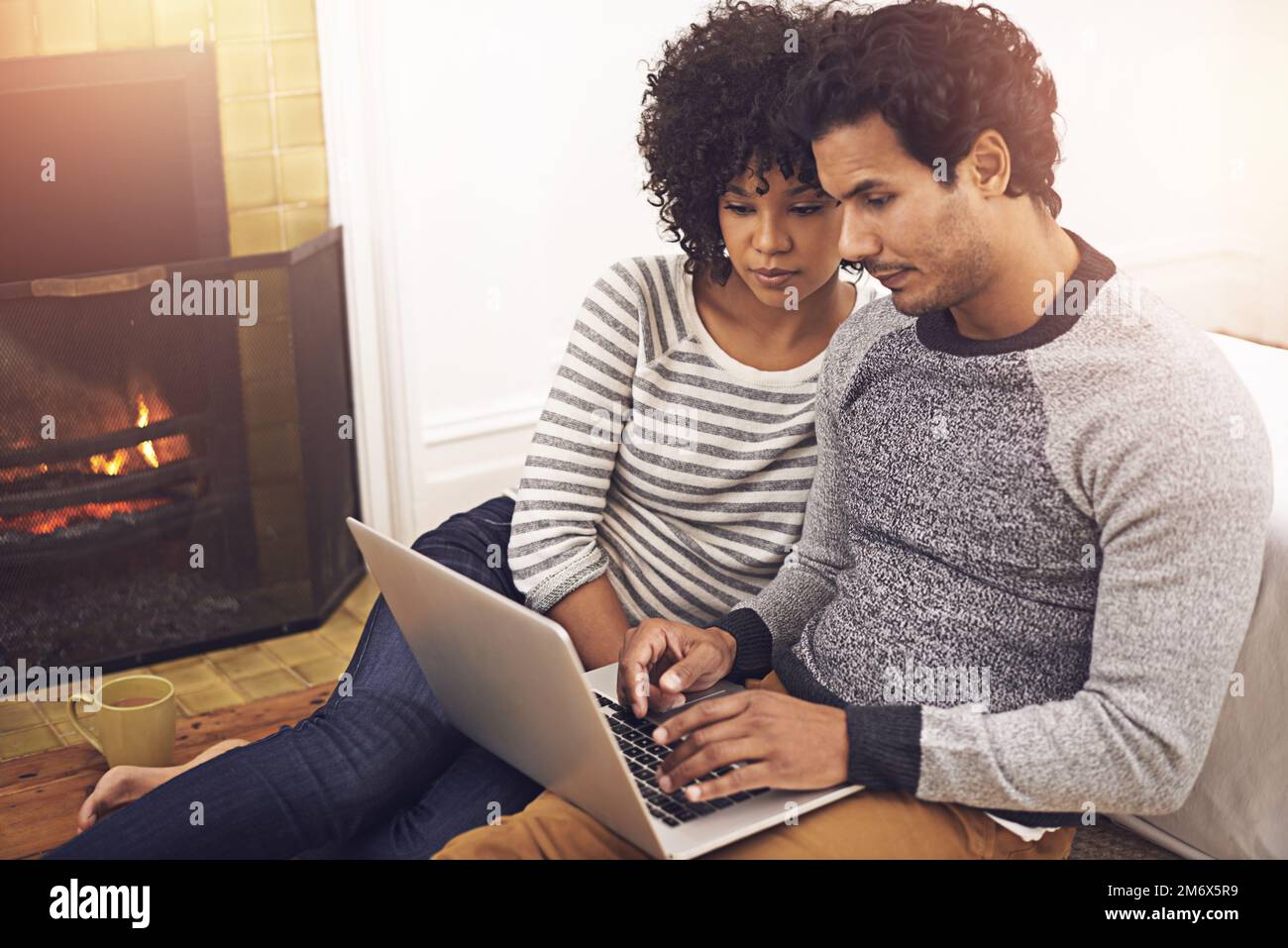 Enjoying their couples night in. a couple using their laptop while ...