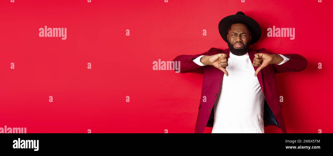 Disappointed Black man leave negative feedback, showing thumb down and ...
