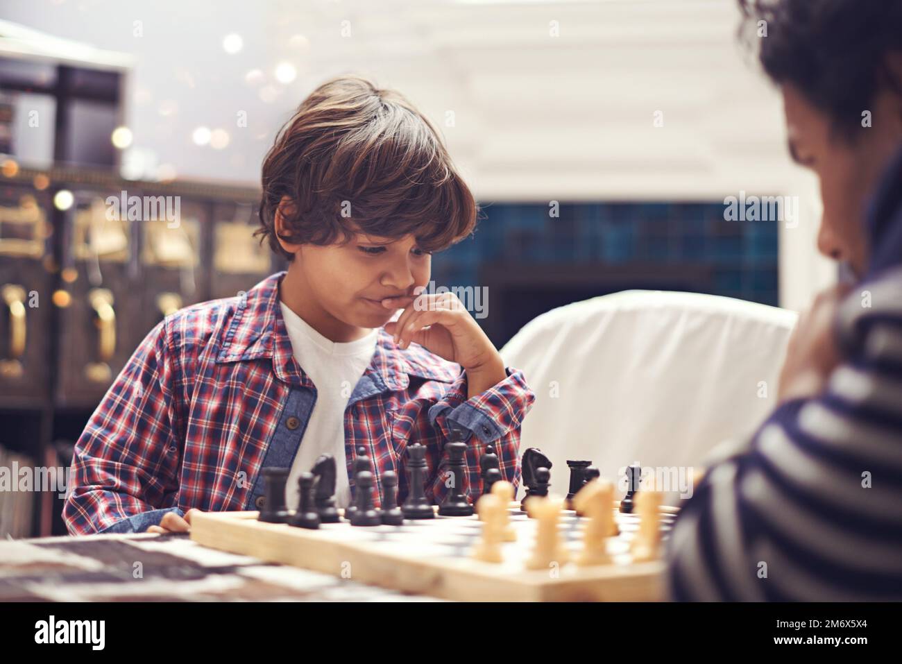Thinking about his next move. a father and son playing a game of chess ...