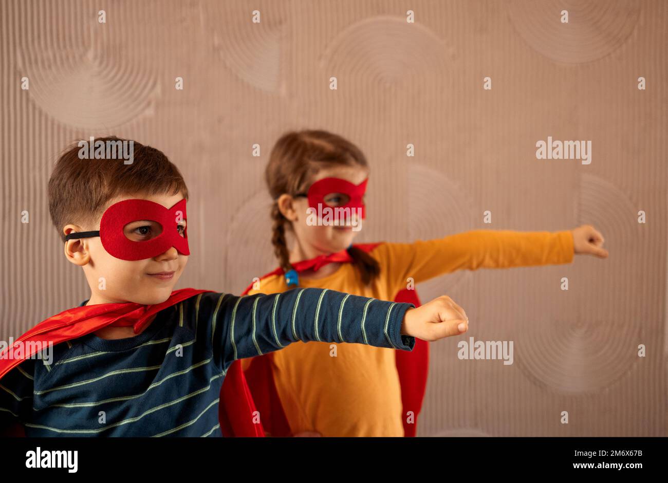 Portrait of a team of two young superheroes, brother and sister, over ...