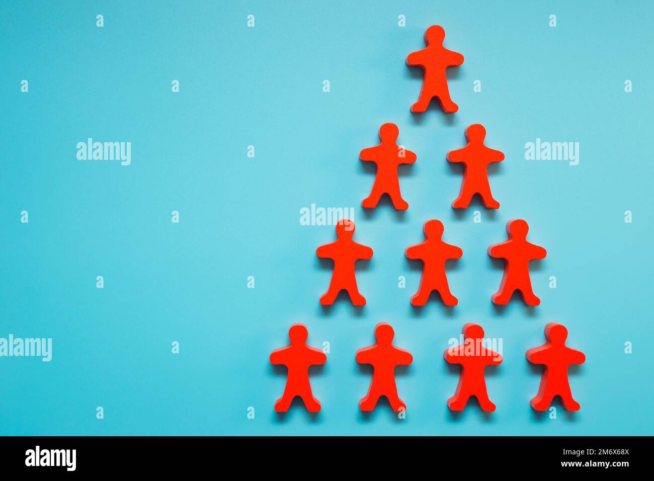 Team of toy people showing concept of teamwork. Pyramid of red toy ...