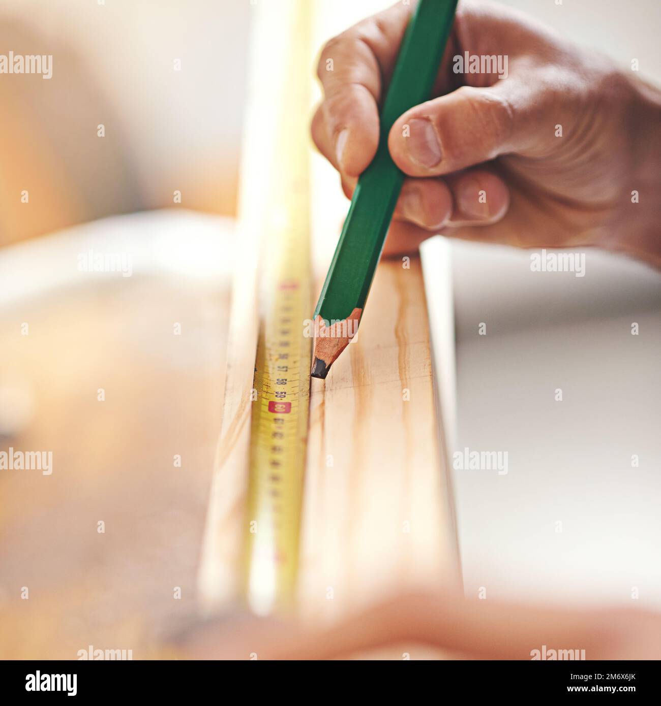 This work takes precision. a carpenter making measurements on a plank ...