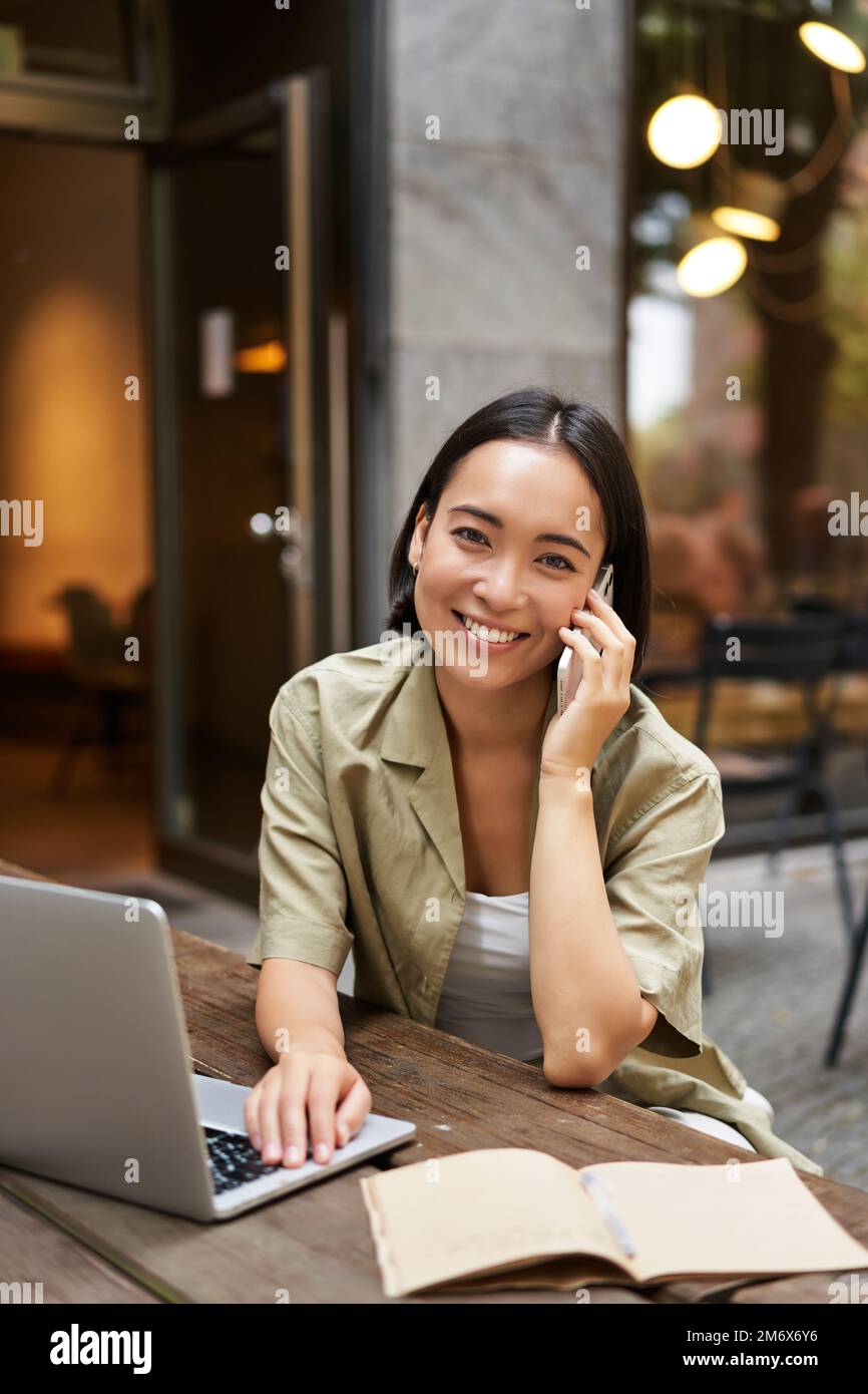Happy girl calling on mobile phone, talking on smartphone and working ...