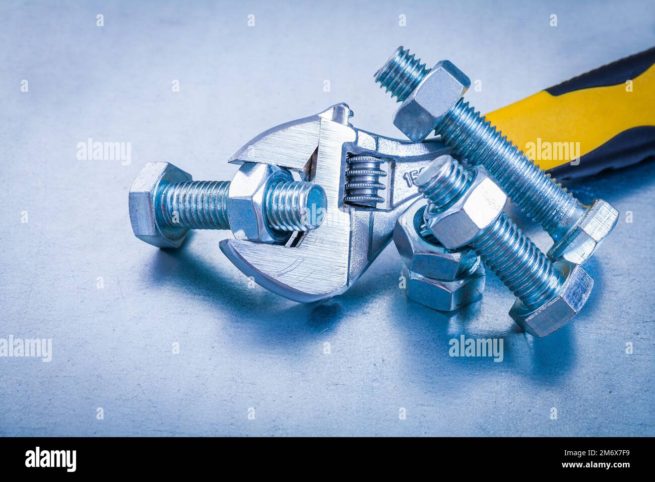 Adjustable spanner bolt details and screw nuts on metallic background ...