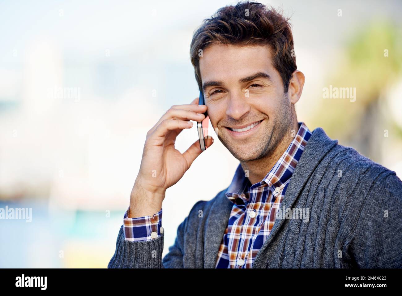 Brighten someones day with a call. a handsome young man making a call ...
