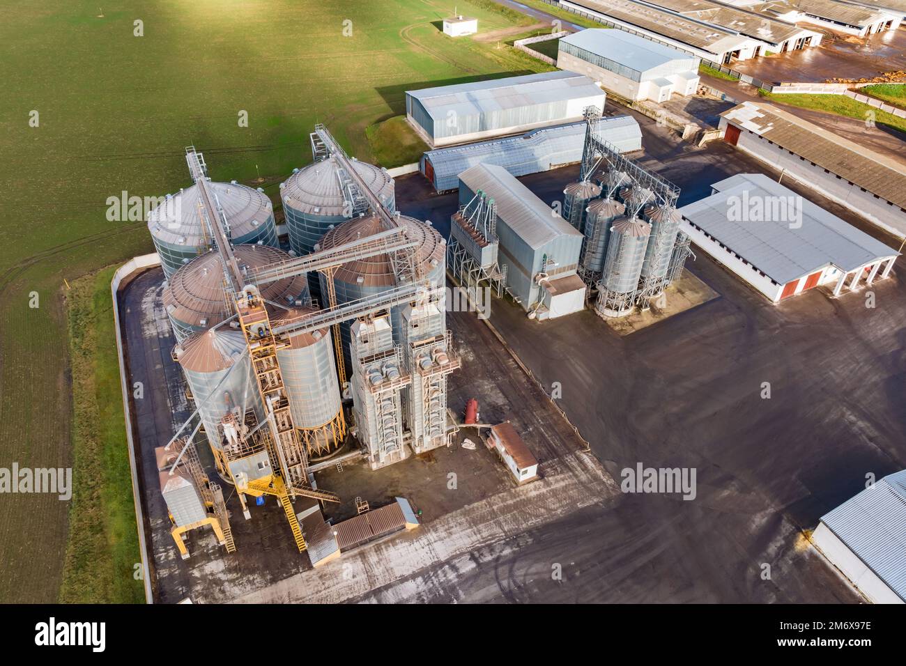 aerial view on agro-industrial complex with silos and grain drying line ...