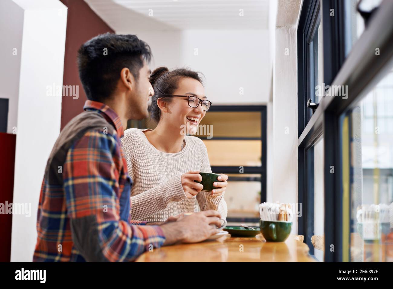 She enjoys going out with him. a young couple sitting in a coffee shop ...
