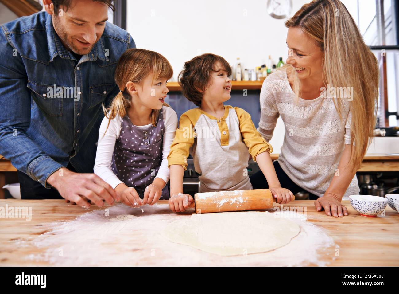 Am I doing it right mom. A family making pizza together at home Stock ...