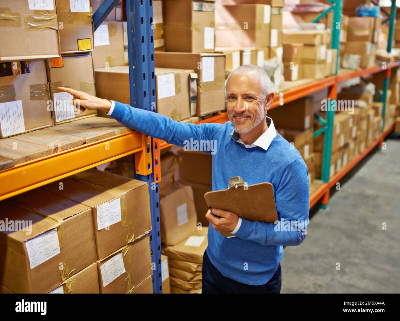 Going through them one at a time. Portrait of a warehouse employee ...