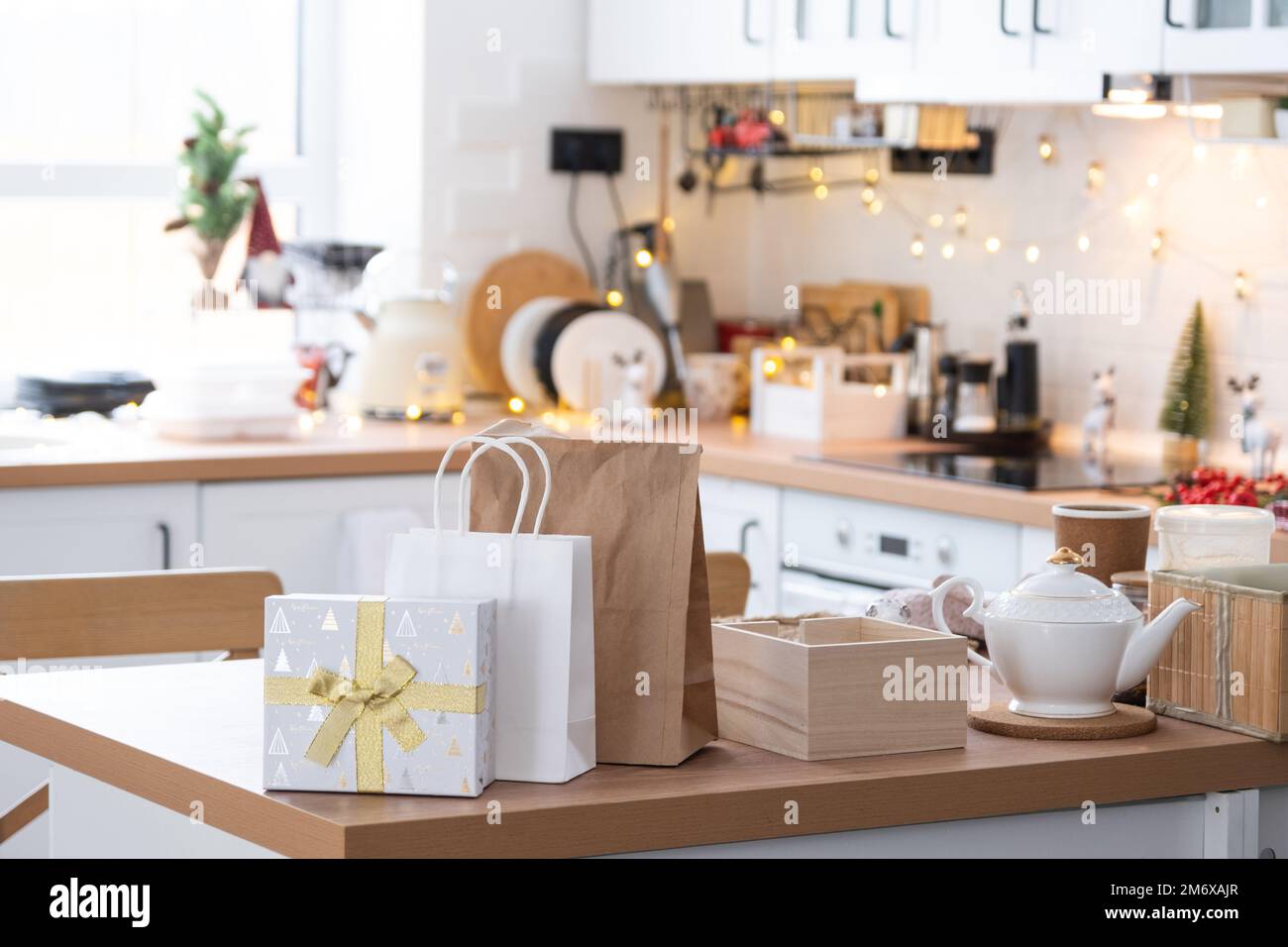 Gift box and packages are on kitchen table decorated for Christmas ...