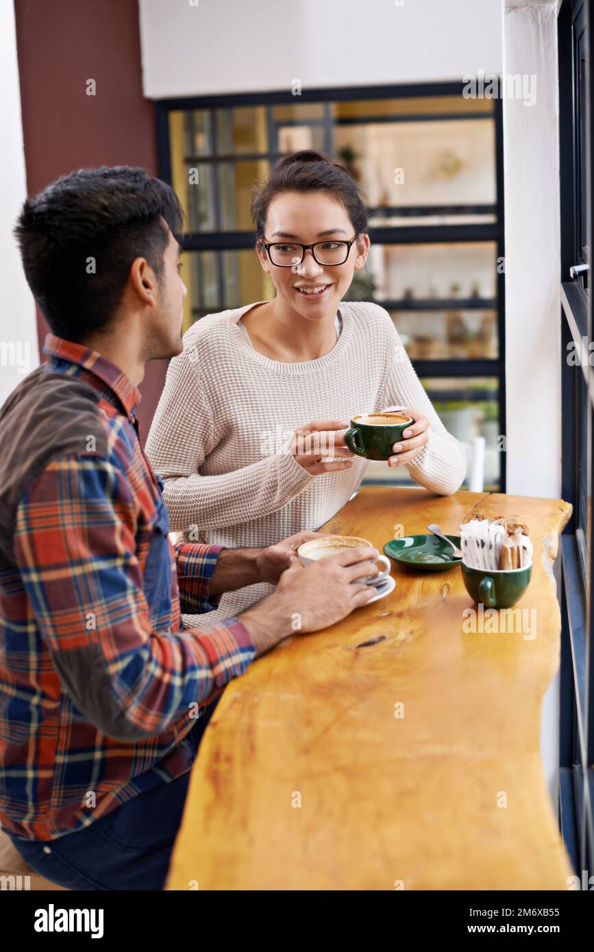 Catching up with her man over coffee. a young couple sitting in a ...