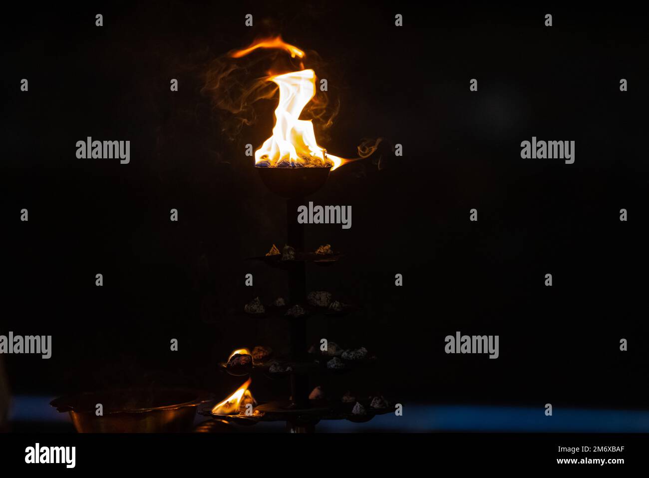 Fire flame at night with dark background during the ganga aarti rituals ...