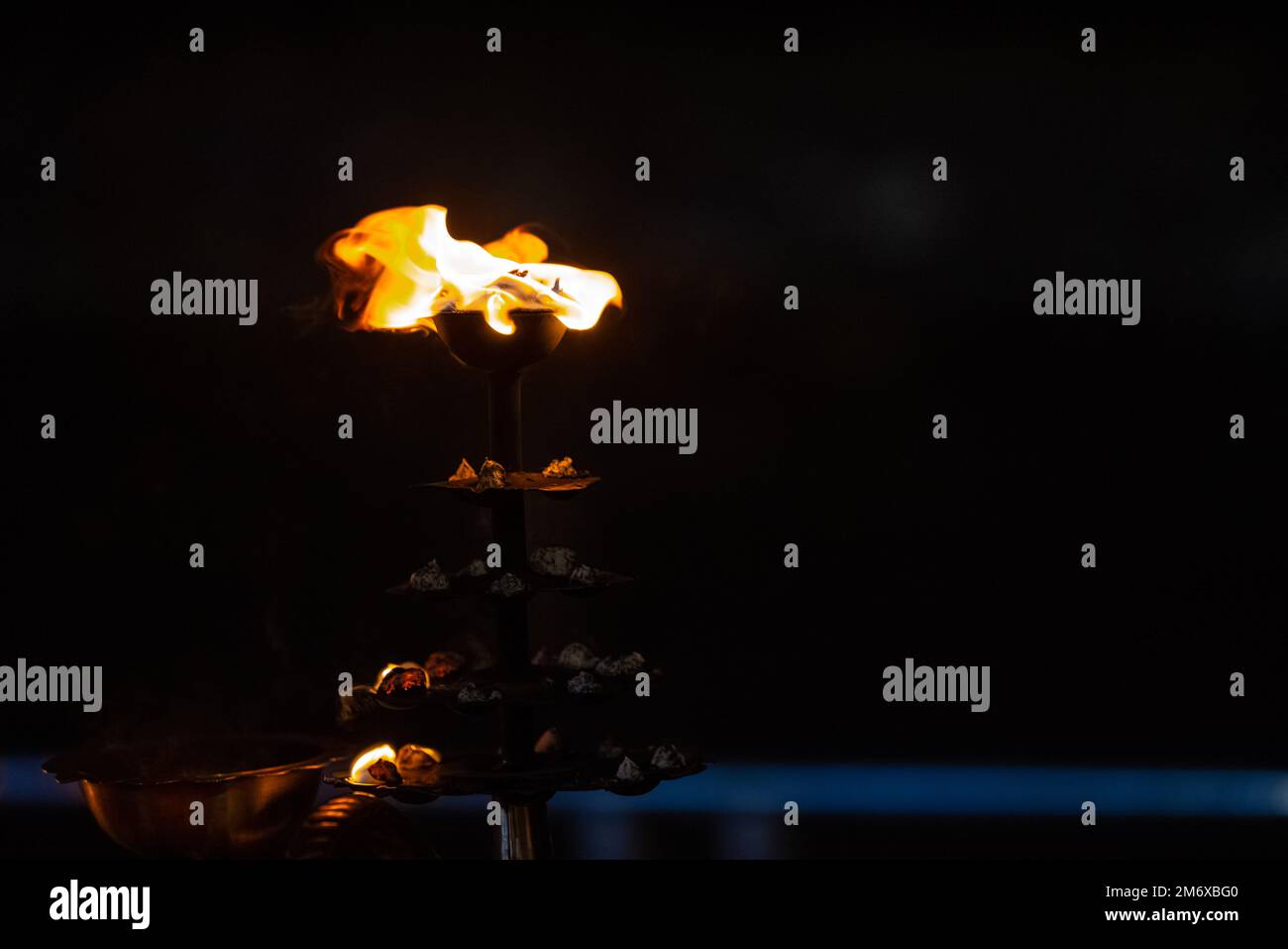 Fire flame at night with dark background during the ganga aarti rituals ...