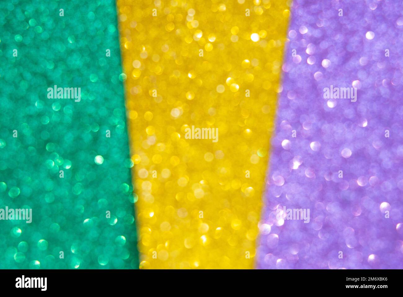 Abstract defocused shiny background gold, green, purple. Mardi gras ...