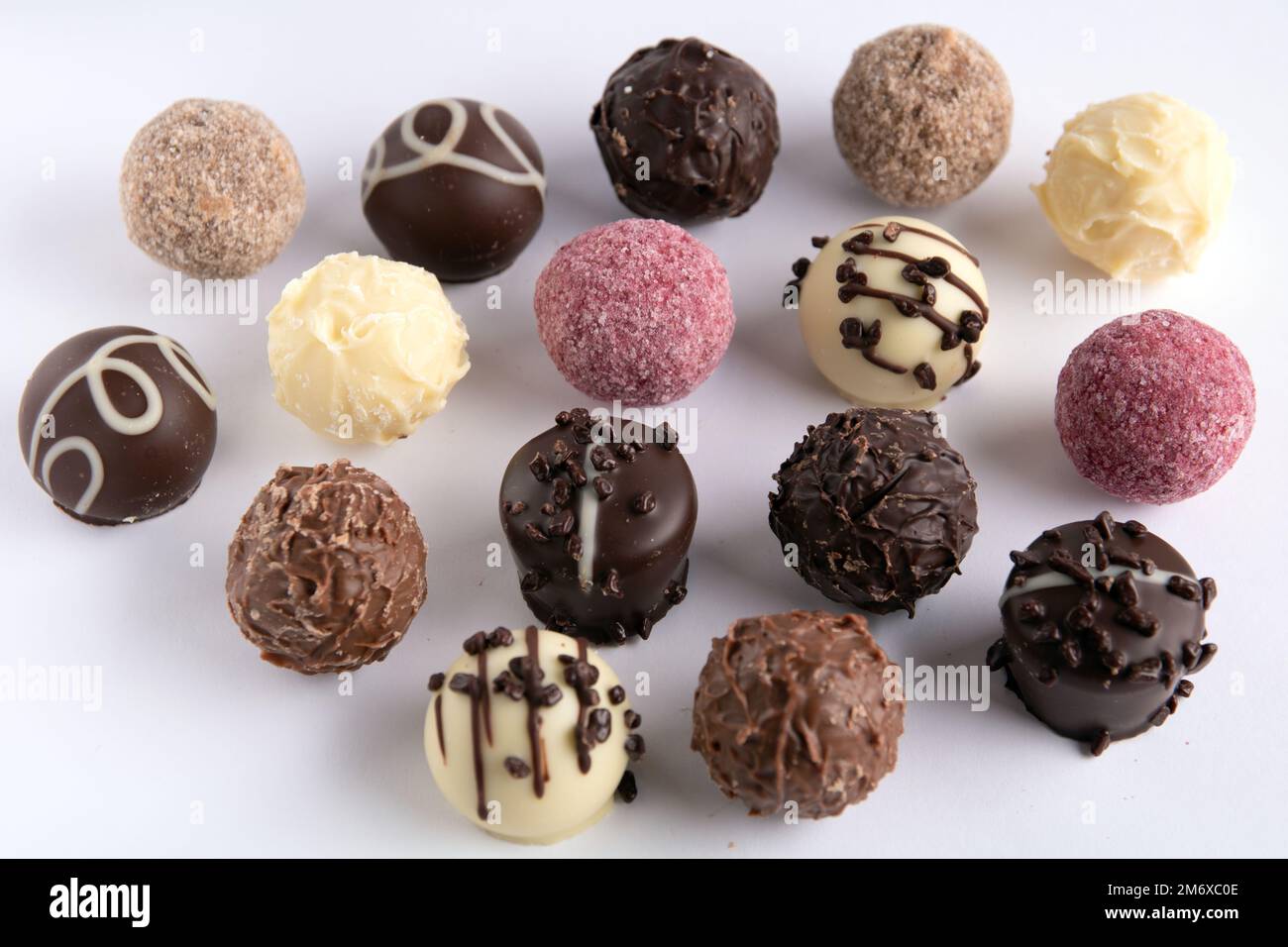 Photo of different chocolate round sweets close-up on a white ...